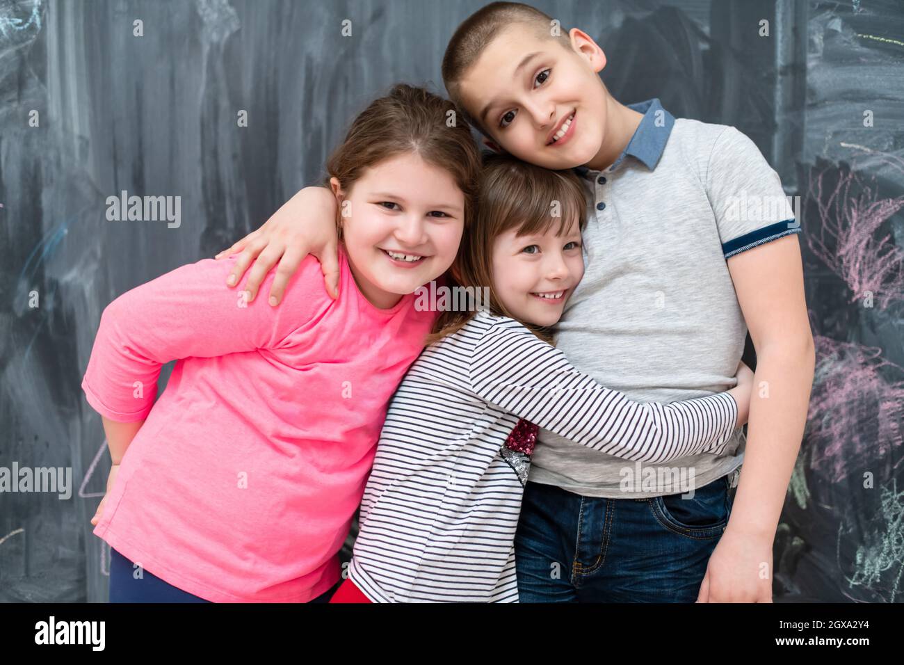 group portrait of happy kids hugging each other while having fun in ...