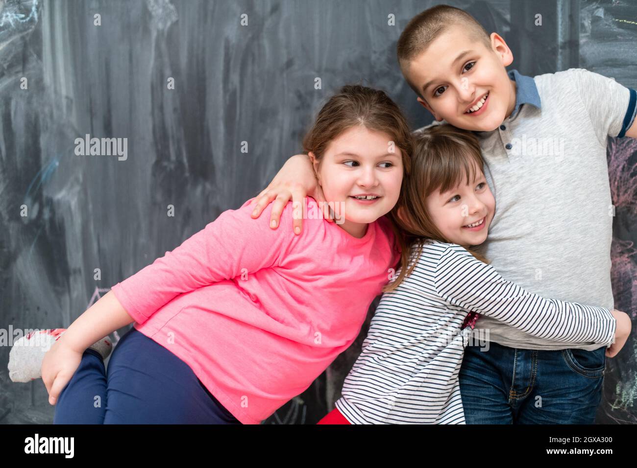 group portrait of happy kids hugging each other while having fun in ...