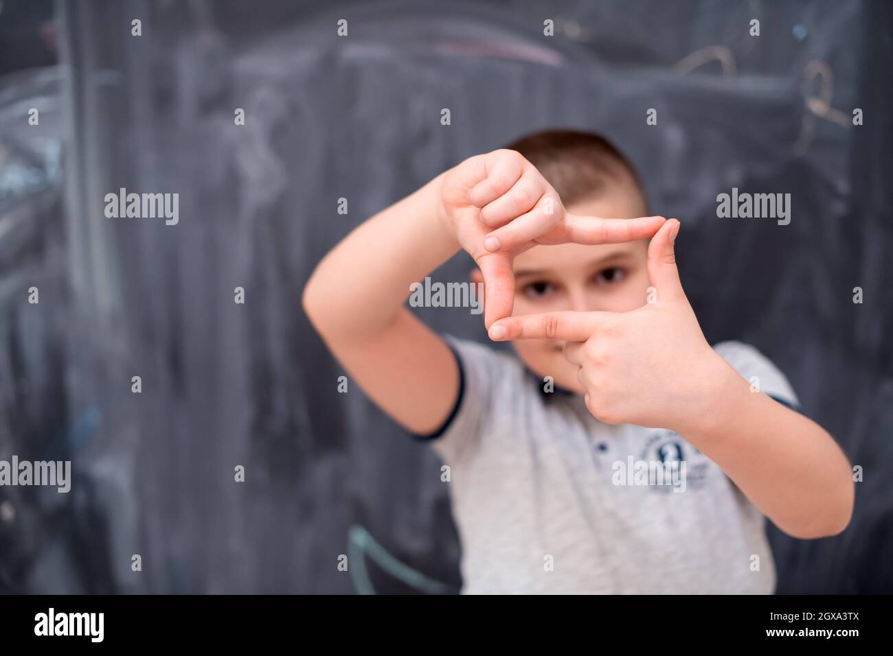 happy cute little boy having fun making hand frame gesture while ...