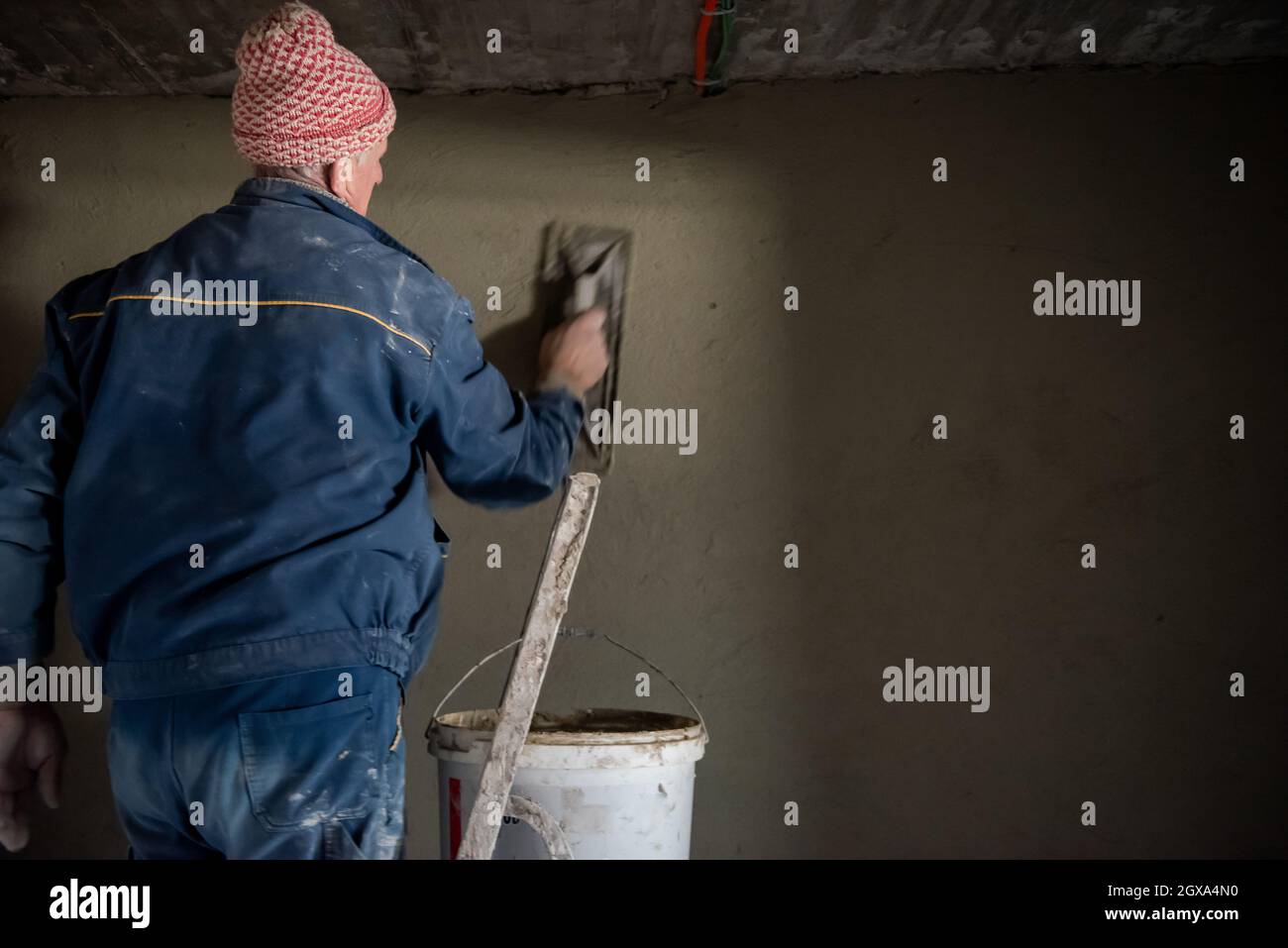 Construction worker plastering interior wall using cement plaster ...