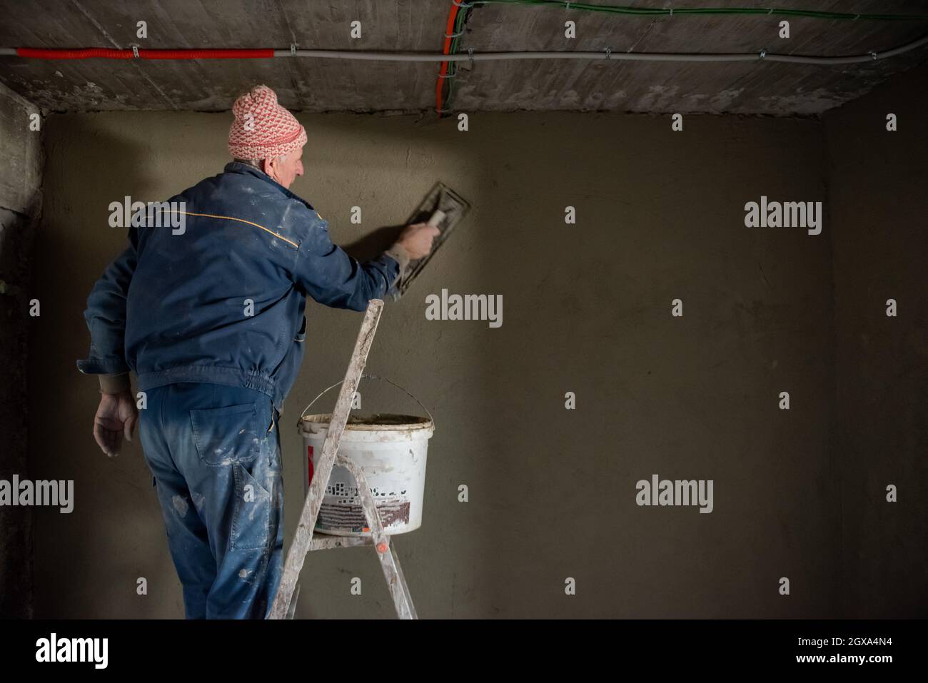 Construction worker plastering interior wall using cement plaster ...