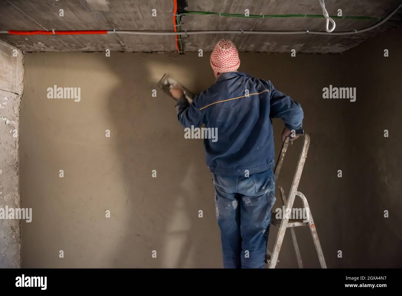 Construction worker plastering interior wall using cement plaster ...