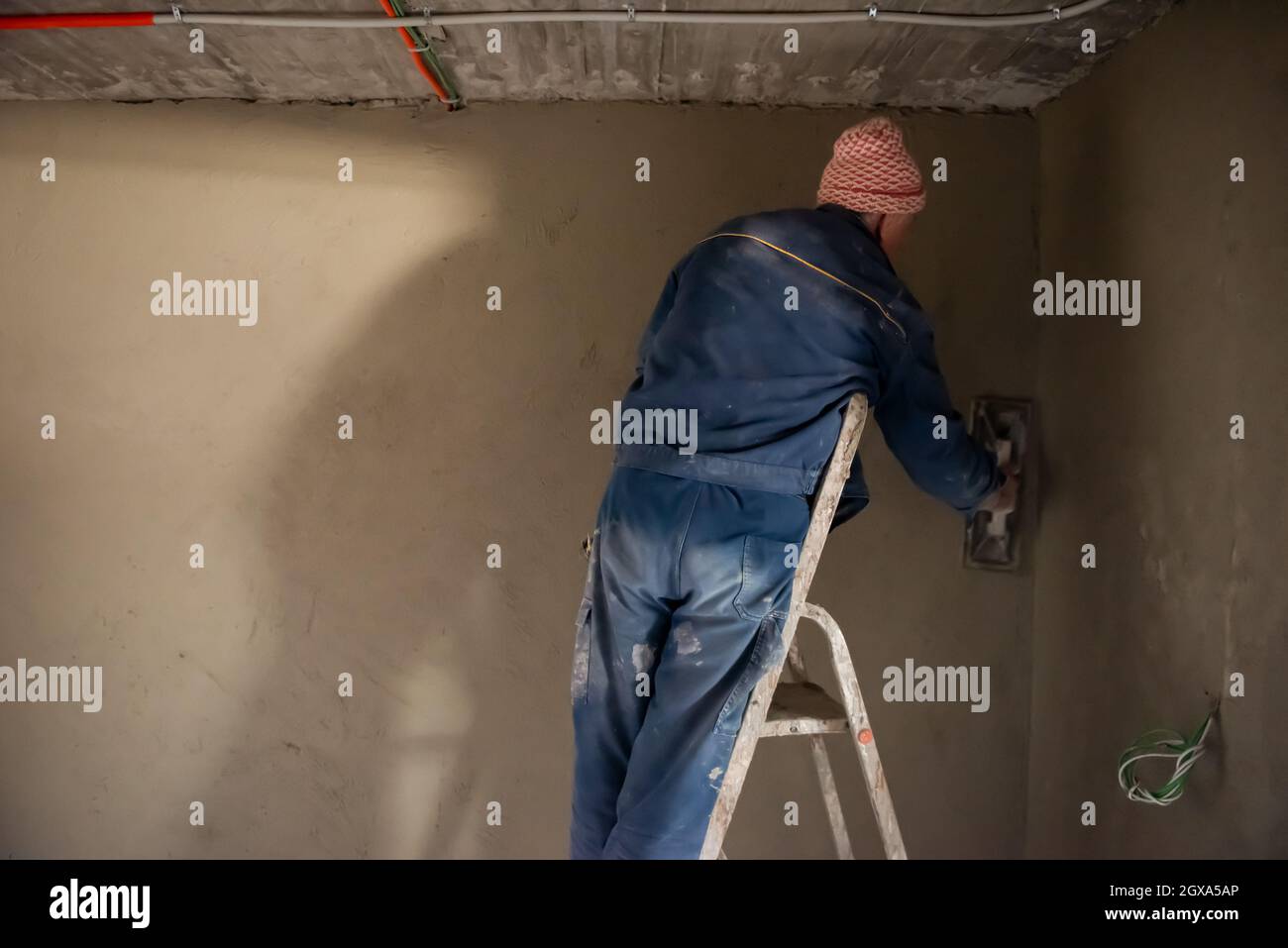 Construction worker plastering interior wall using cement plaster ...