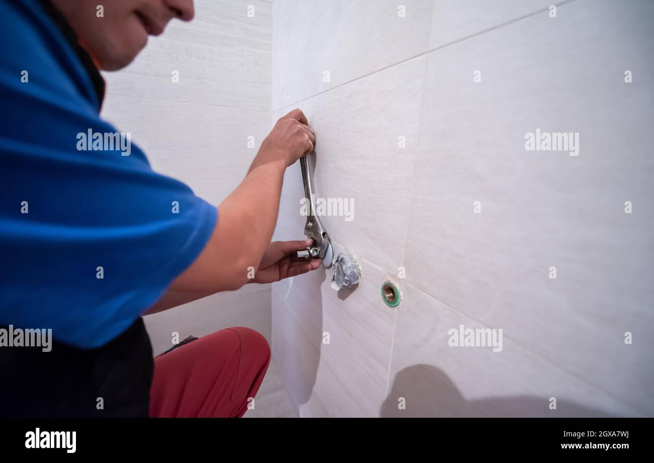 professional plumber working in a bathroom, plumbing repair service ...