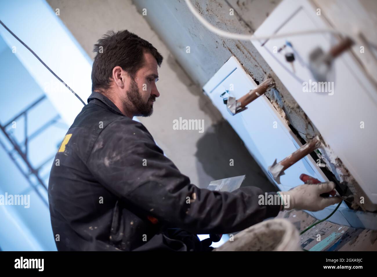 Construction worker plastering interior wall using cement plaster ...