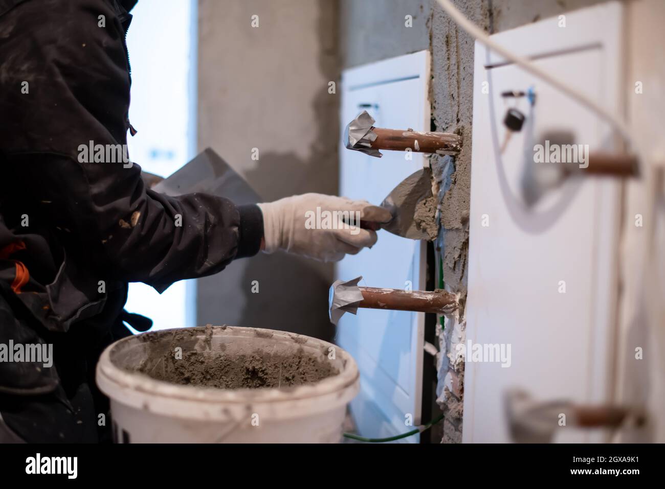 Construction worker plastering interior wall using cement plaster ...