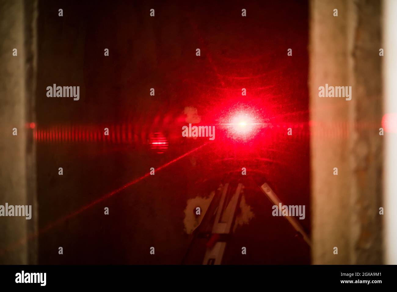 professional worker using laser level in a building under construction ...