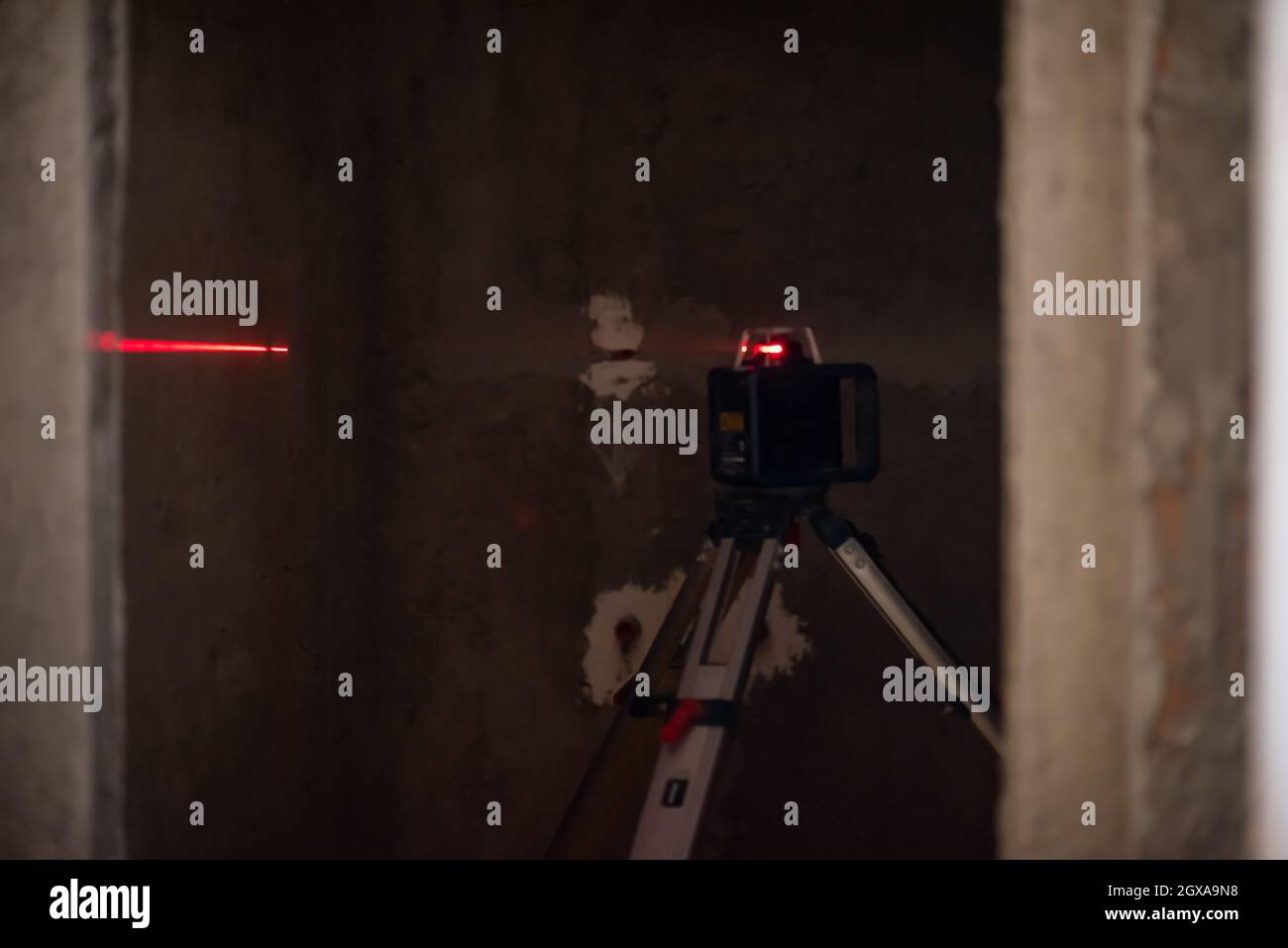 professional worker using laser level in a building under construction ...