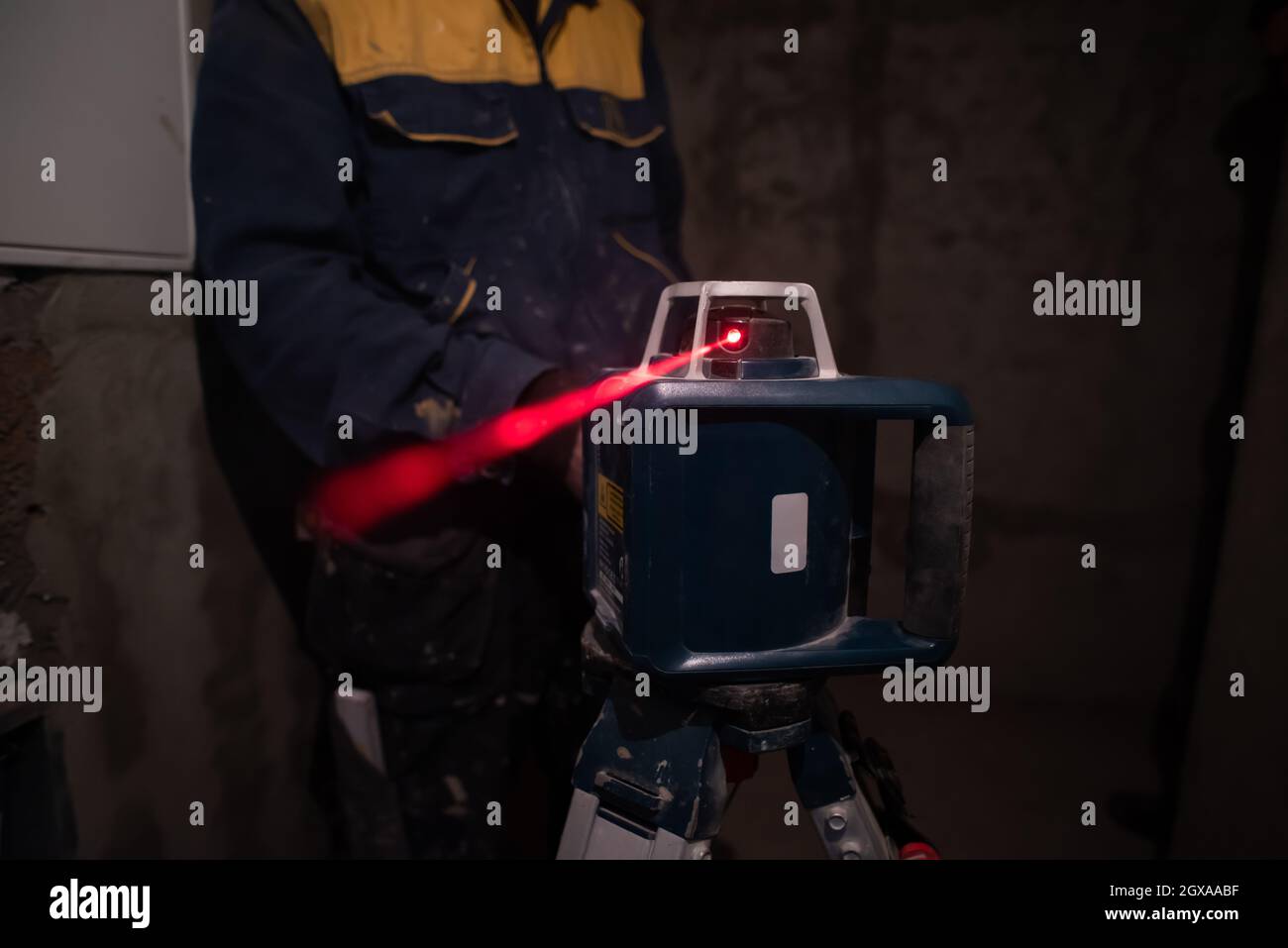 professional worker using laser level in a building under construction ...