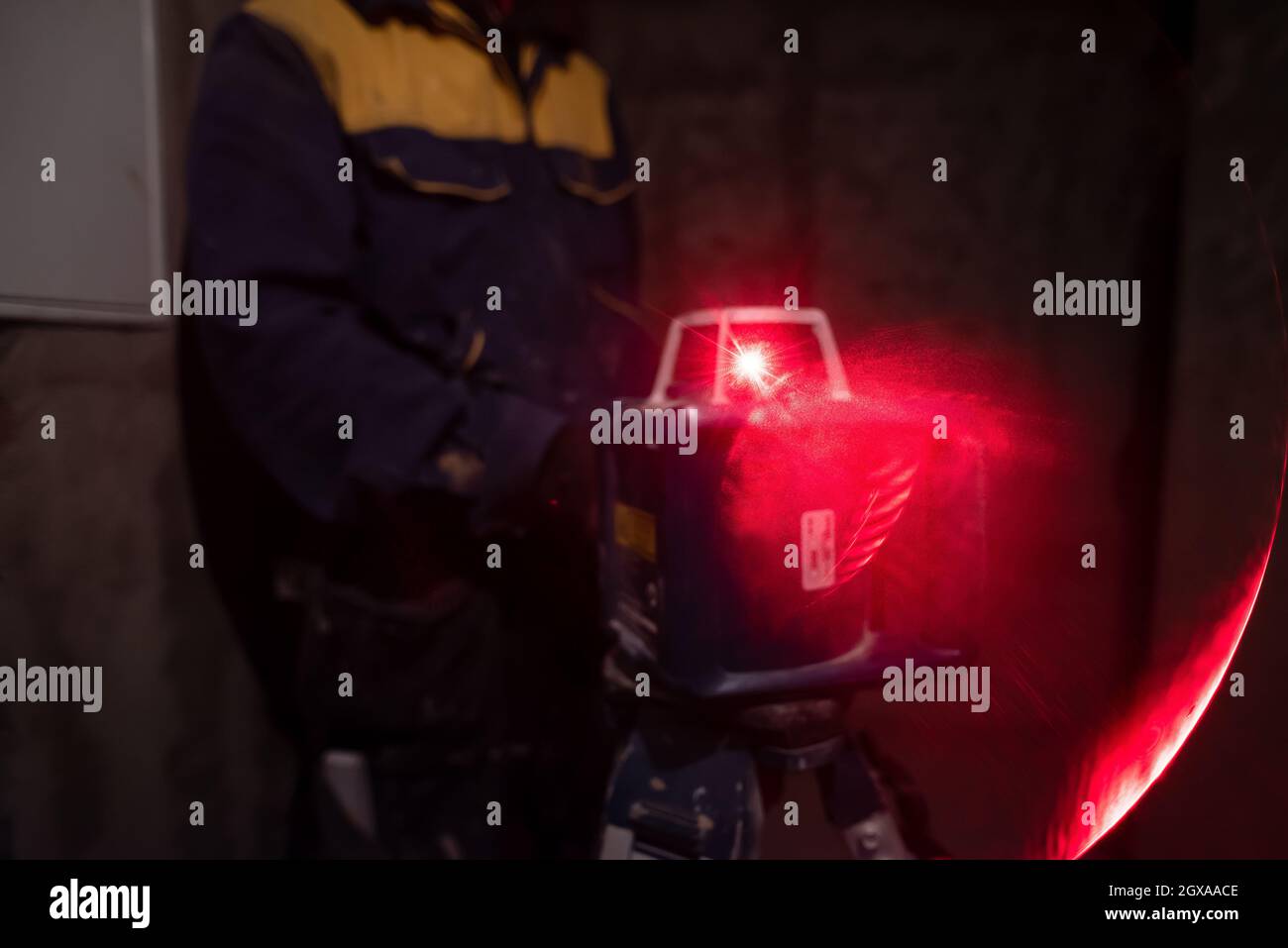 professional worker using laser level in a building under construction ...