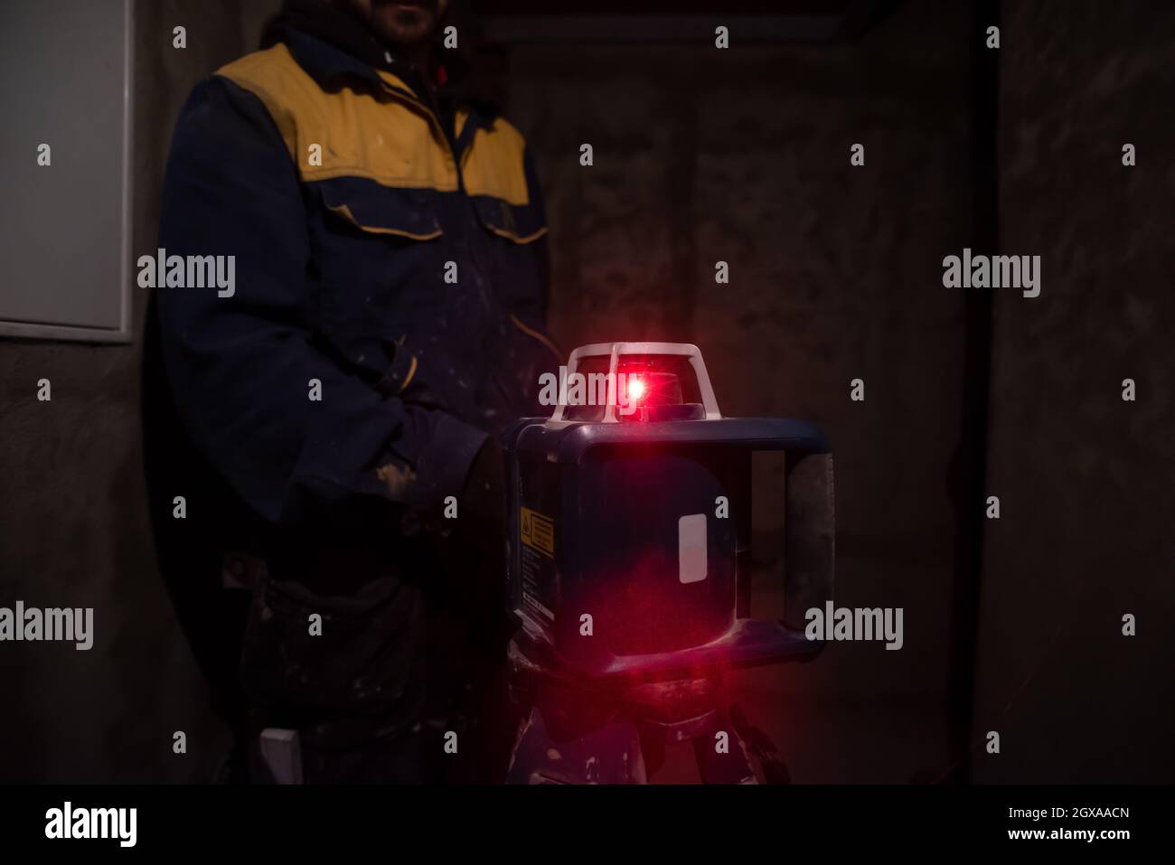 professional worker using laser level in a building under construction ...