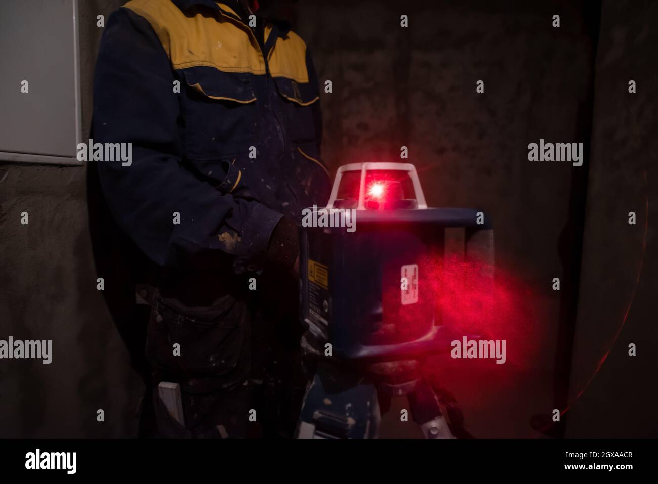 professional worker using laser level in a building under construction ...