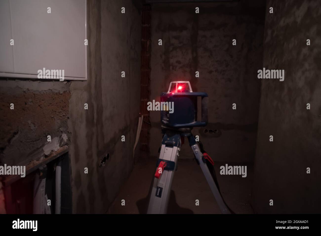 professional worker using laser level in a building under construction ...