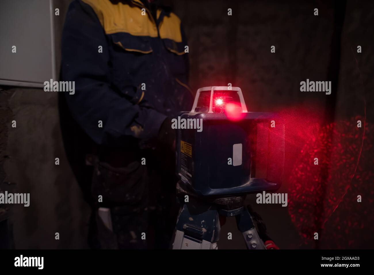 professional worker using laser level in a building under construction ...
