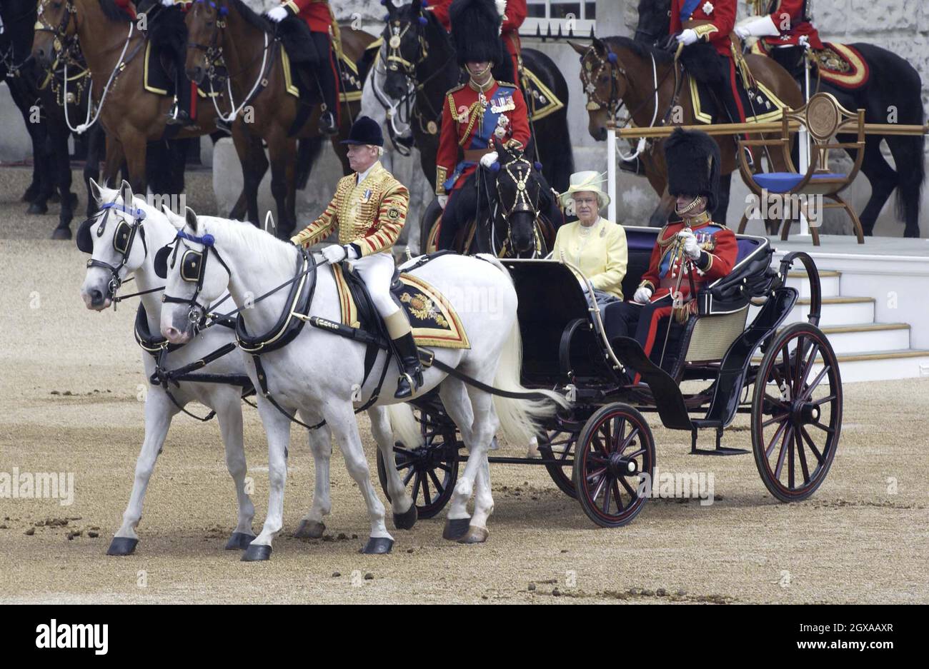 Queen Elizabeth II rides in a carriage flanked by The Prince of Wales ...