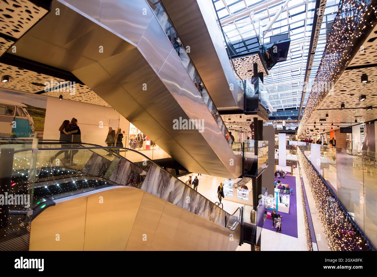 Shoppers walking through luxury shopping mall interior Interior of big ...