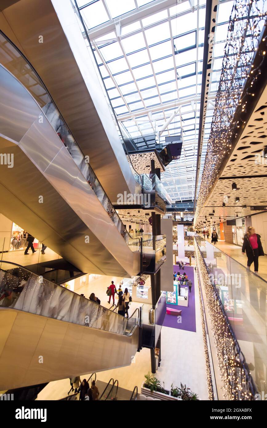 Shoppers walking through luxury shopping mall interior Interior of big ...