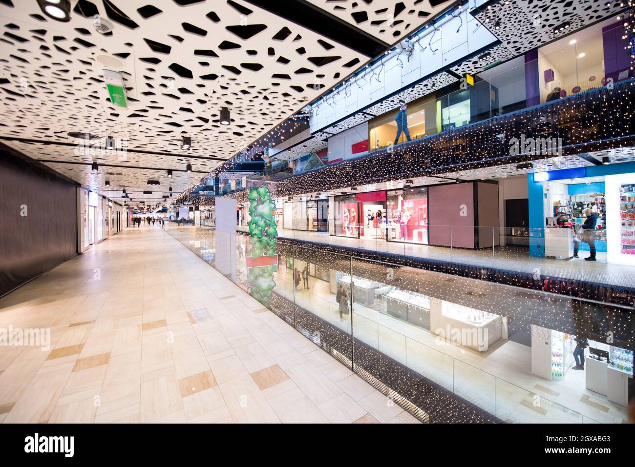 Shoppers walking through luxury shopping mall interior Interior of big ...