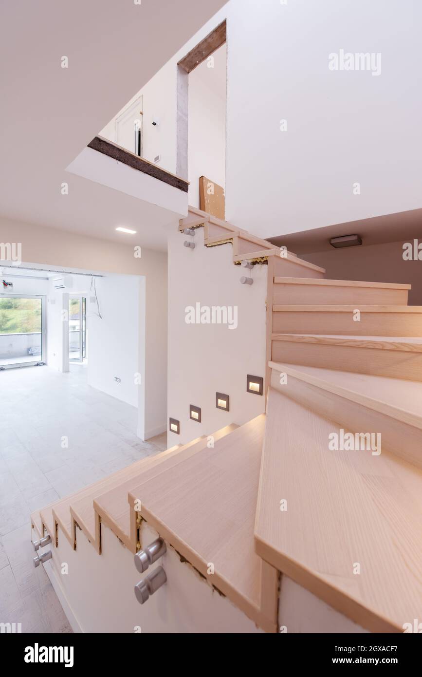 stylish interior with wooden stairs in big modern two level luxury ...