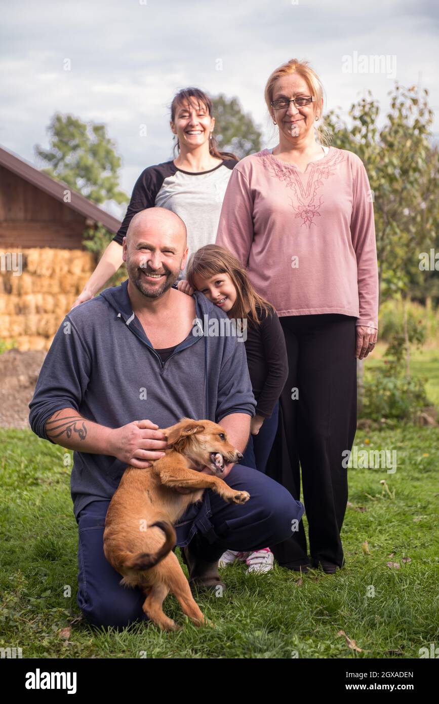 portrait of happy three generations family with dog at beautiful ...