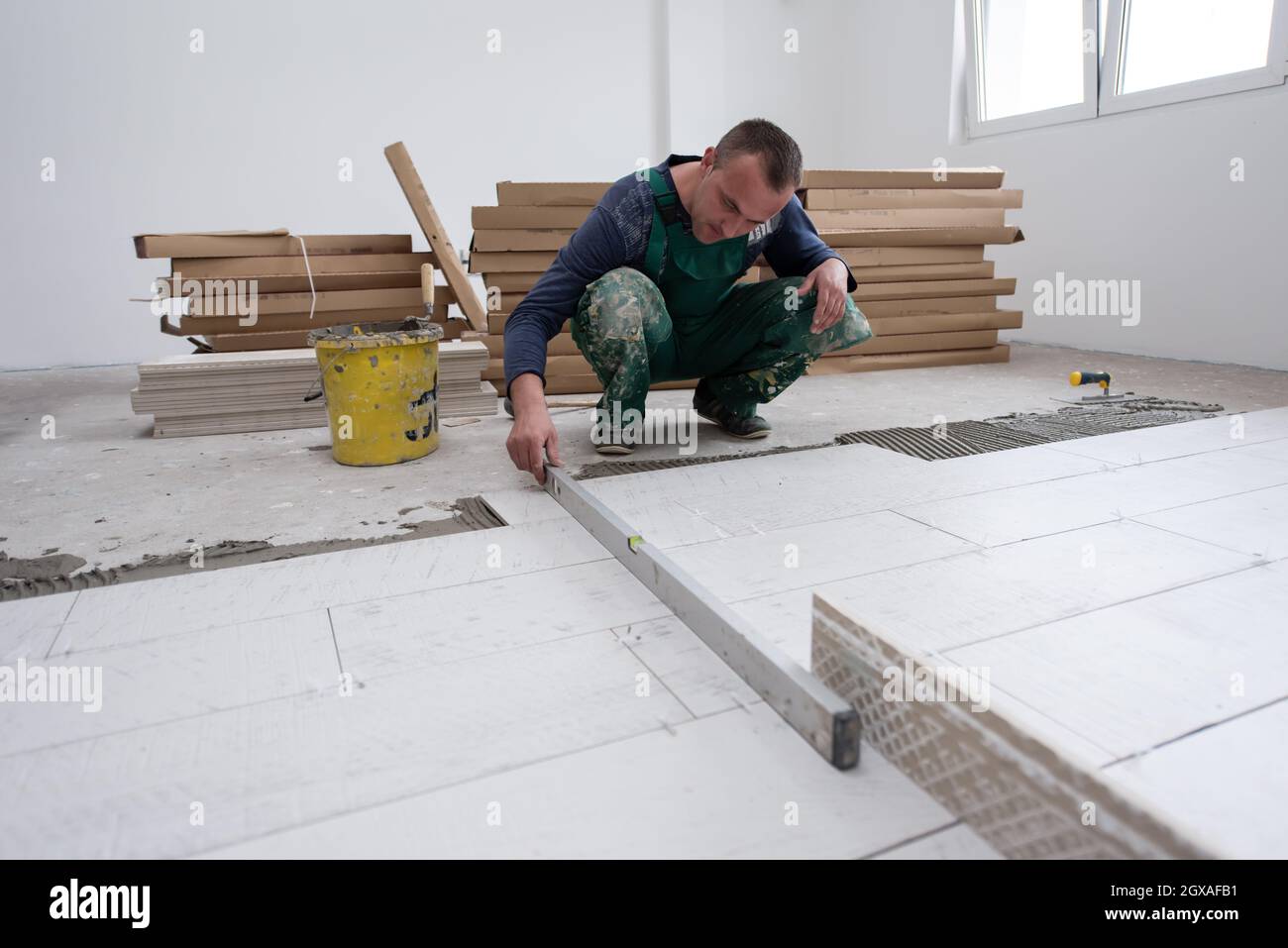 skilled worker installing the ceramic wood effect tiles on the floor ...
