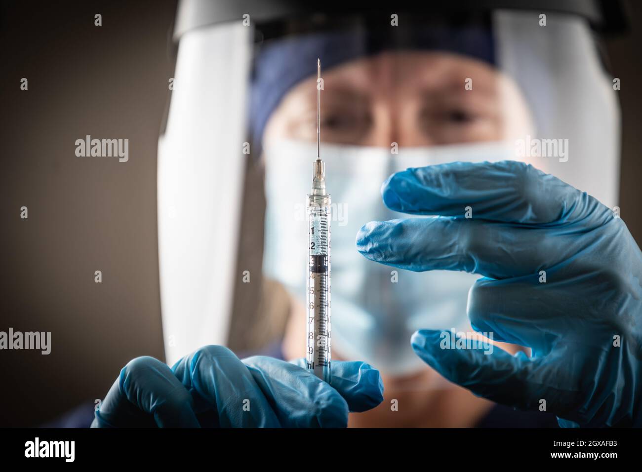 Doctor or Nurse Holding Medical Syringe with Needle AGainst Dark ...
