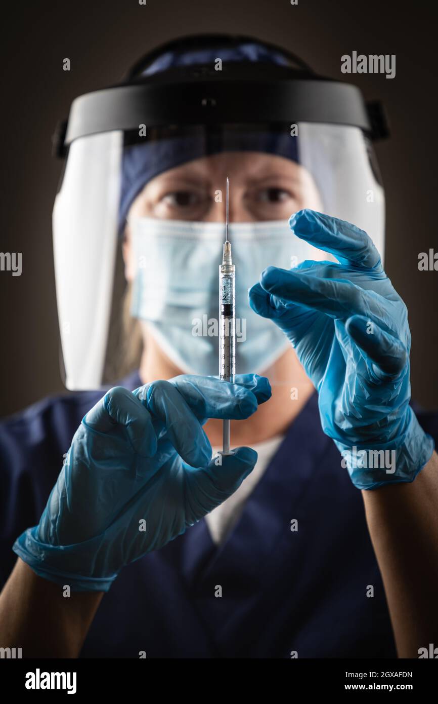 Doctor or Nurse Holding Medical Syringe with Needle AGainst Dark ...