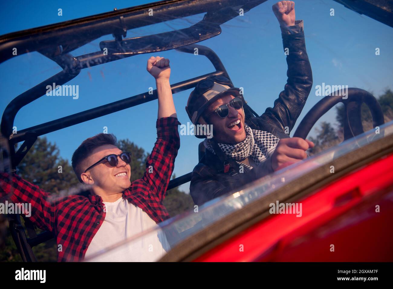 two young happy excited men enjoying beautiful sunny day while driving ...