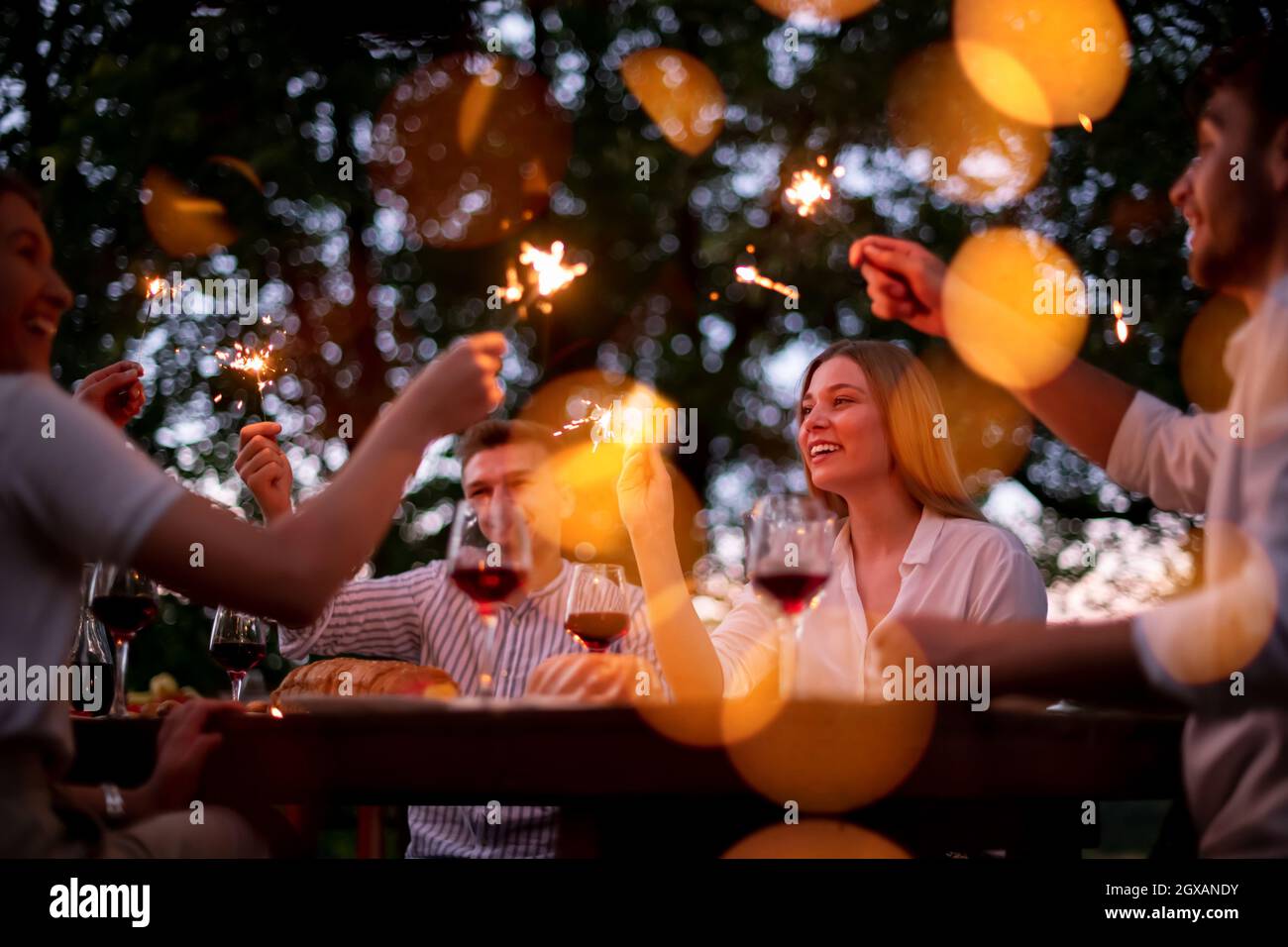 group of happy friends celebrating holiday vacation using sprinklers ...