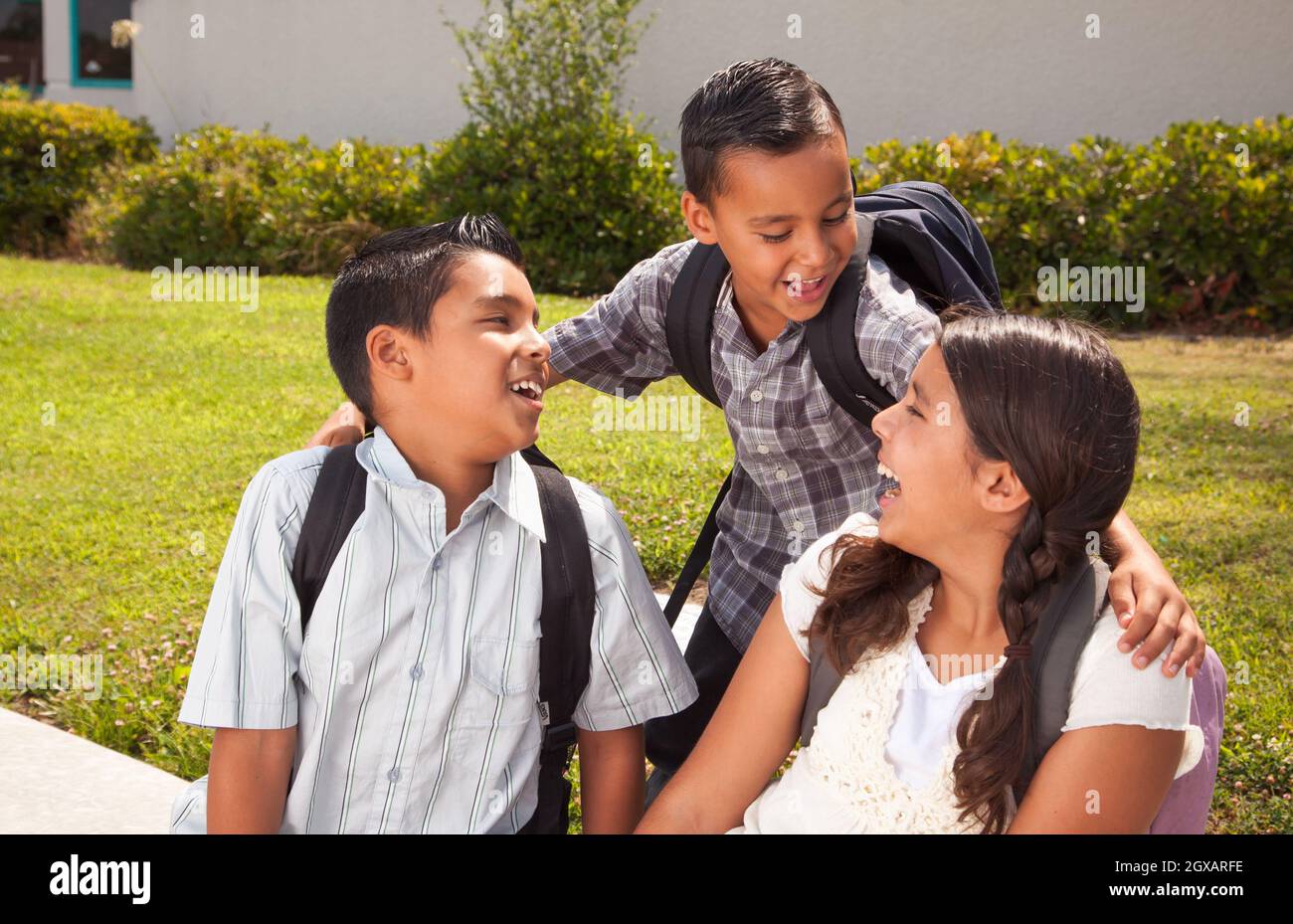 Young Hispanic Student Children Wearing Backpacks On School Campus ...