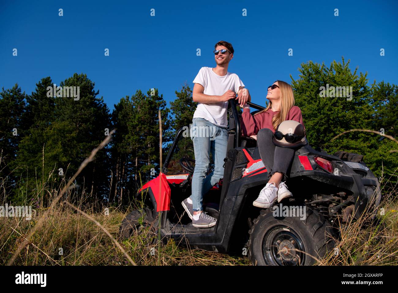 portrait of young happy excited couple enjoying beautiful sunny day while driving a off road ...