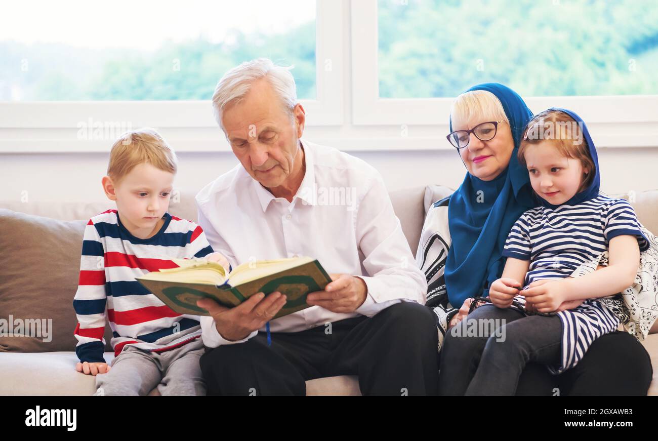 modern muslim family grandparents with grandchildren reading Quran and ...