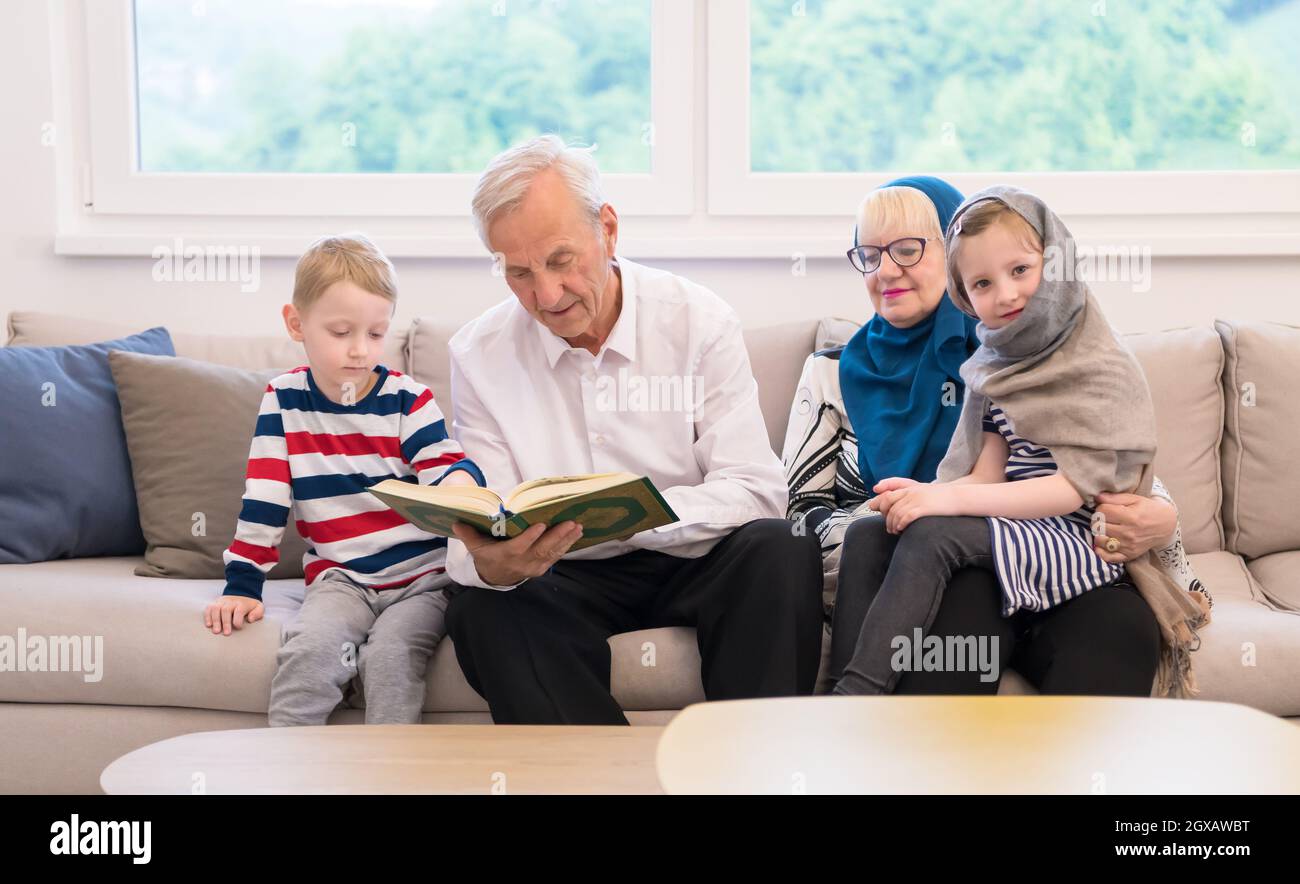 modern muslim family grandparents with grandchildren reading Quran and ...