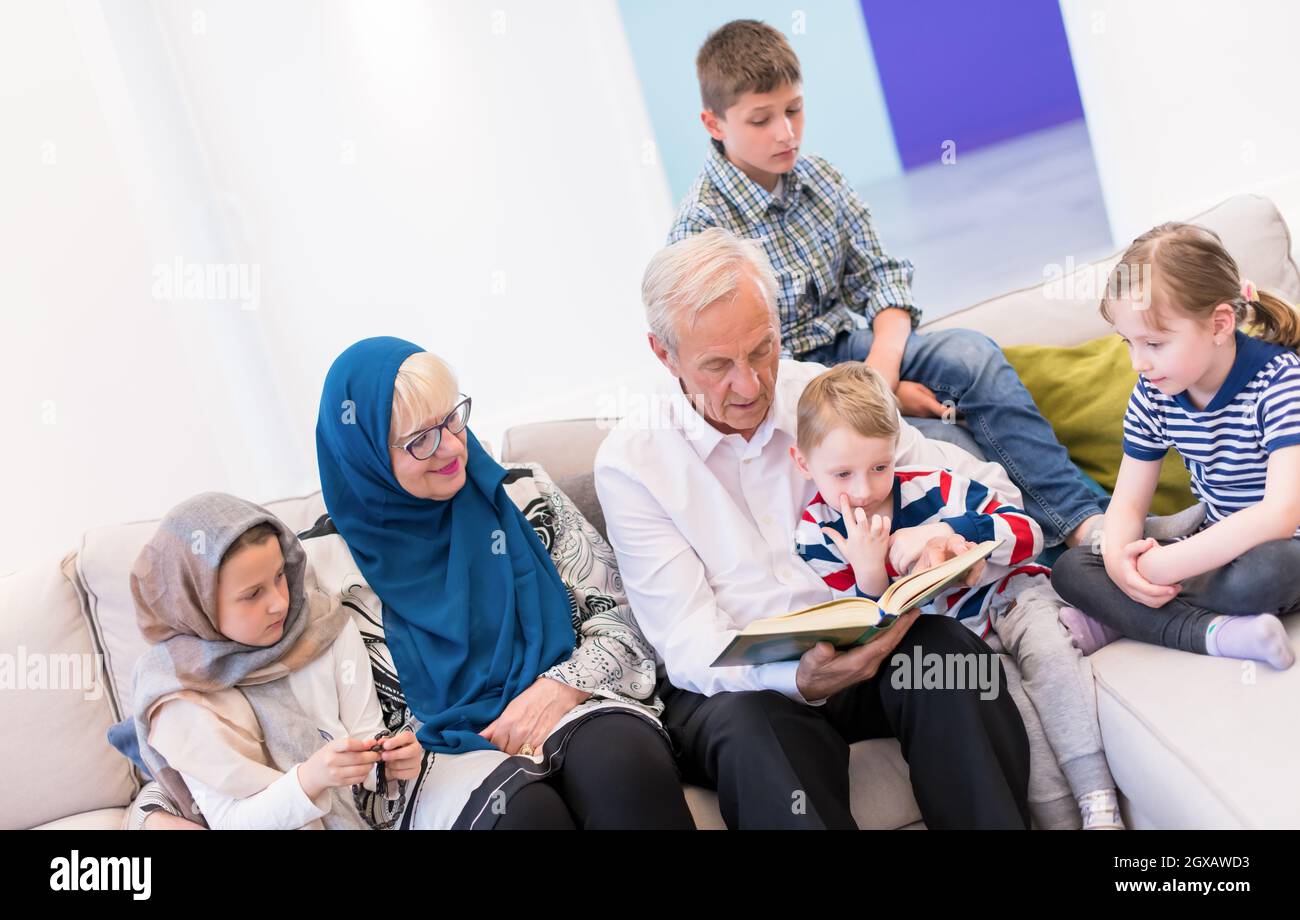 modern muslim family grandparents with grandchildren reading Quran and ...