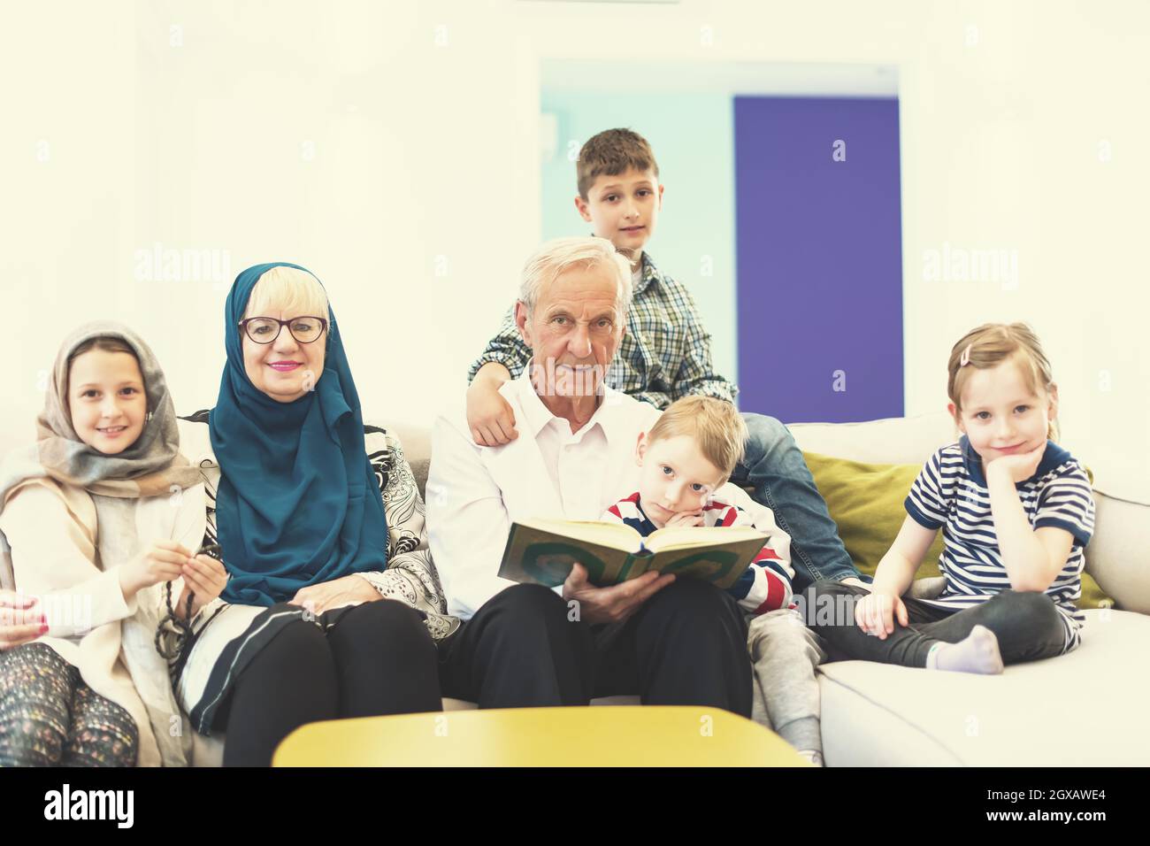 modern muslim family grandparents with grandchildren reading Quran and ...