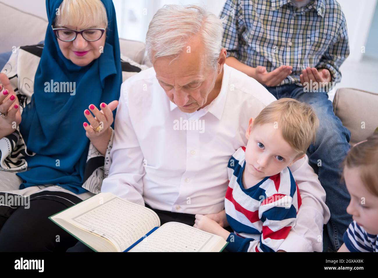 modern muslim family grandparents with grandchildren reading Quran and ...