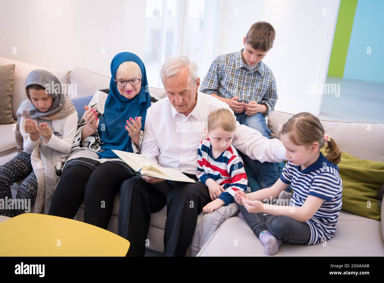 modern muslim family grandparents with grandchildren reading Quran and ...
