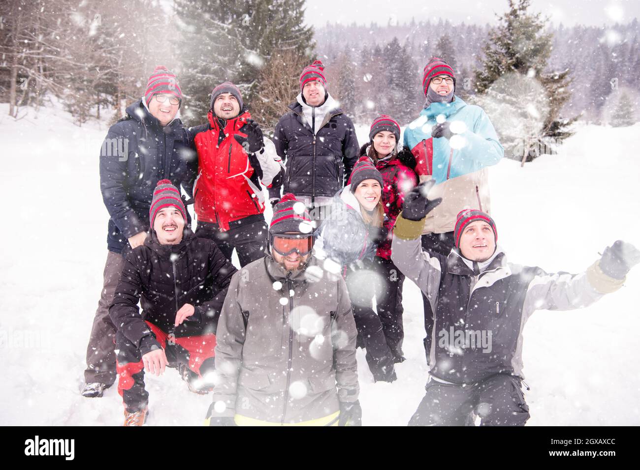 group portrait of young happy business people enjoying snowy winter day with snowflakes around ...