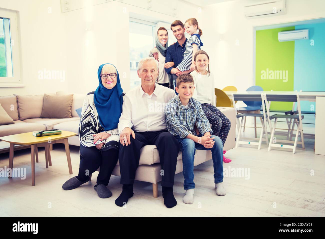 several generations portrait of happy modern muslim family before iftar ...