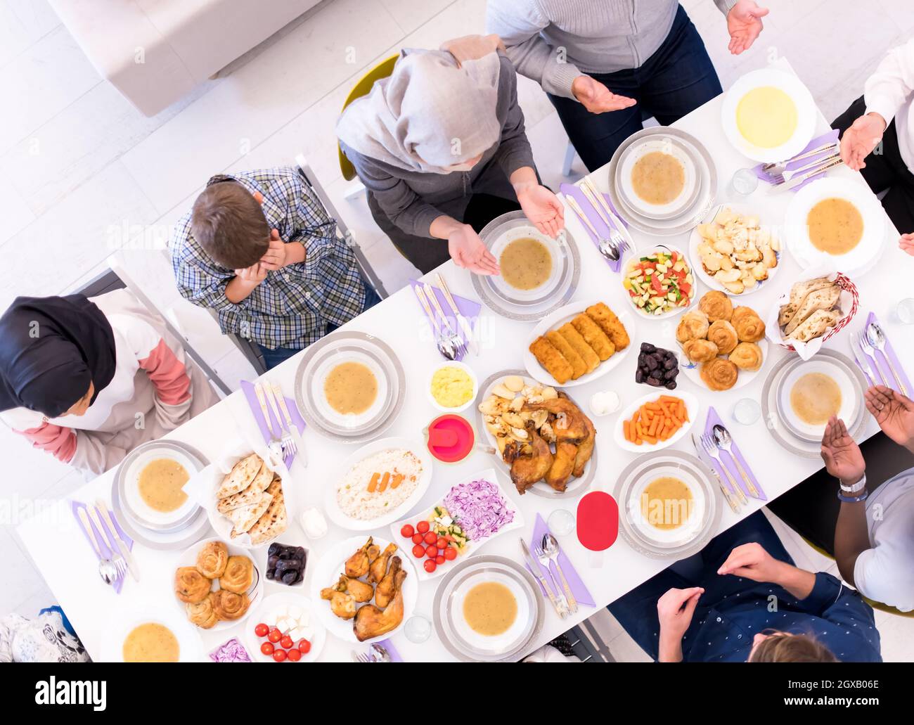 top view of modern multiethnic muslim family praying before having ...