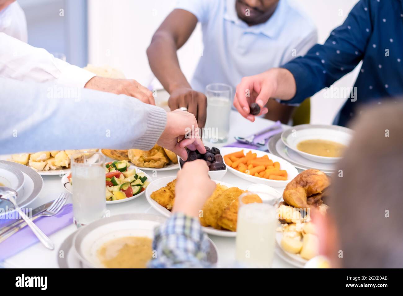 modern multiethnic muslim family sharing a bowl of dates while enjoying ...