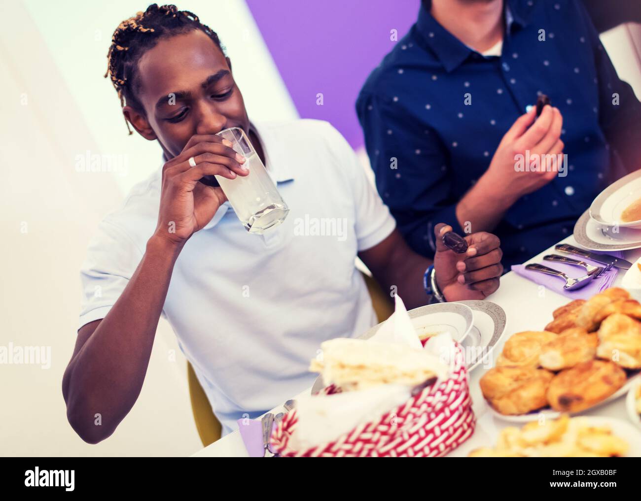 african american man enjoying iftar dinner together with modern ...