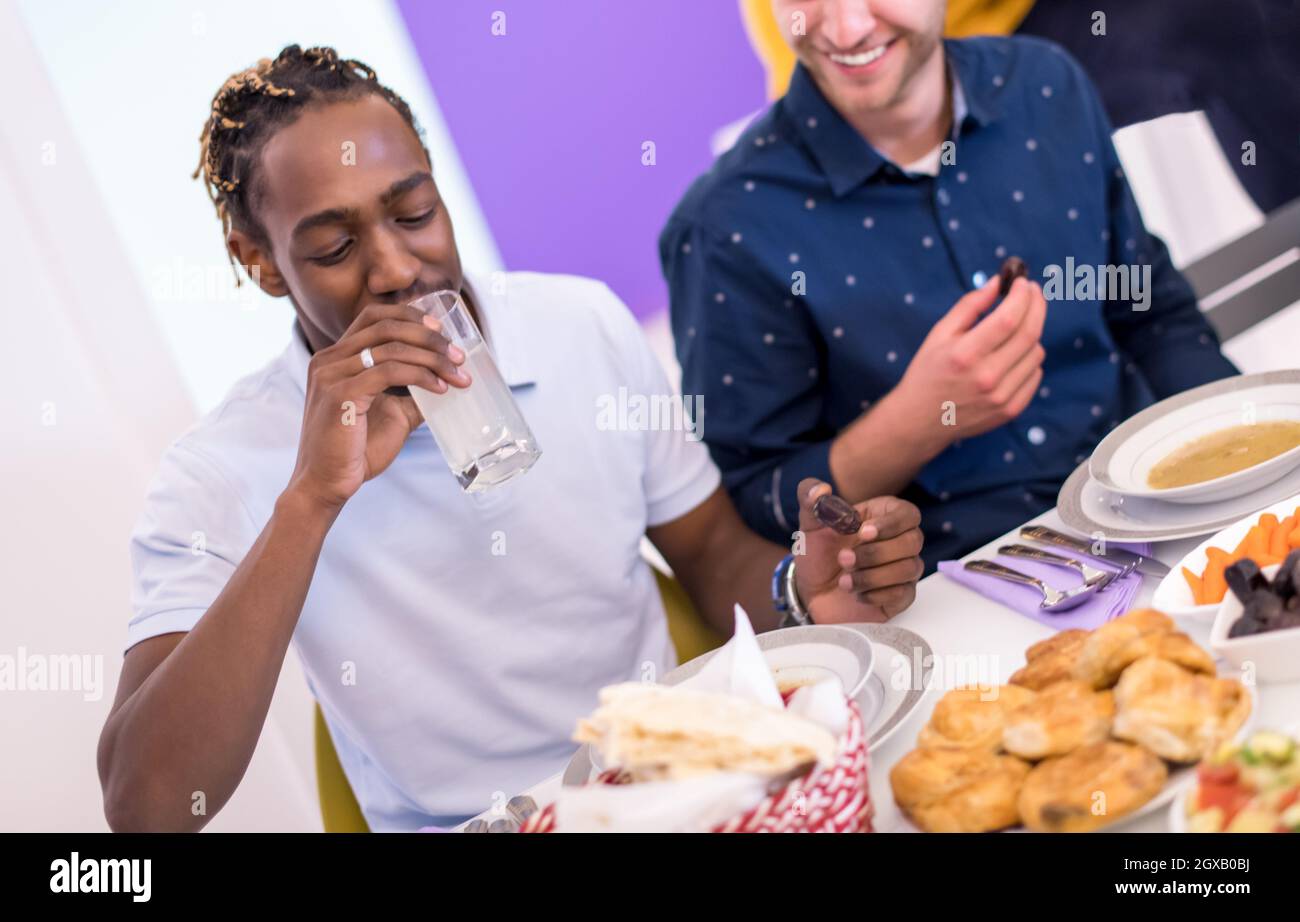 african american man enjoying iftar dinner together with modern ...