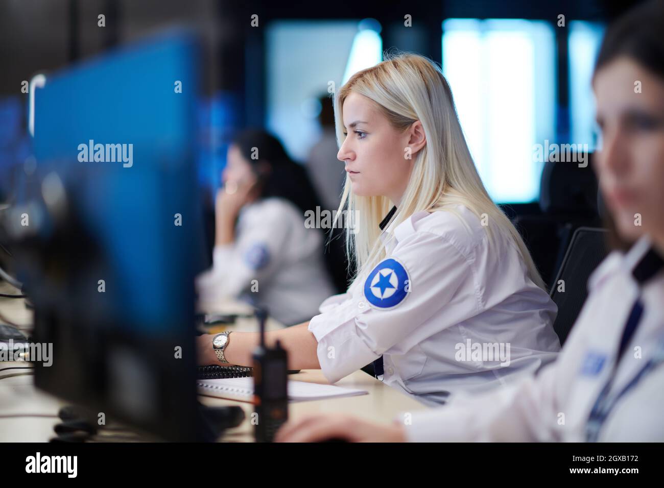 Female security operator working in a data system control room offices ...