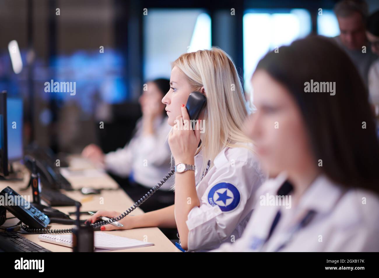 Female security guard operator talking on the phone while working at ...