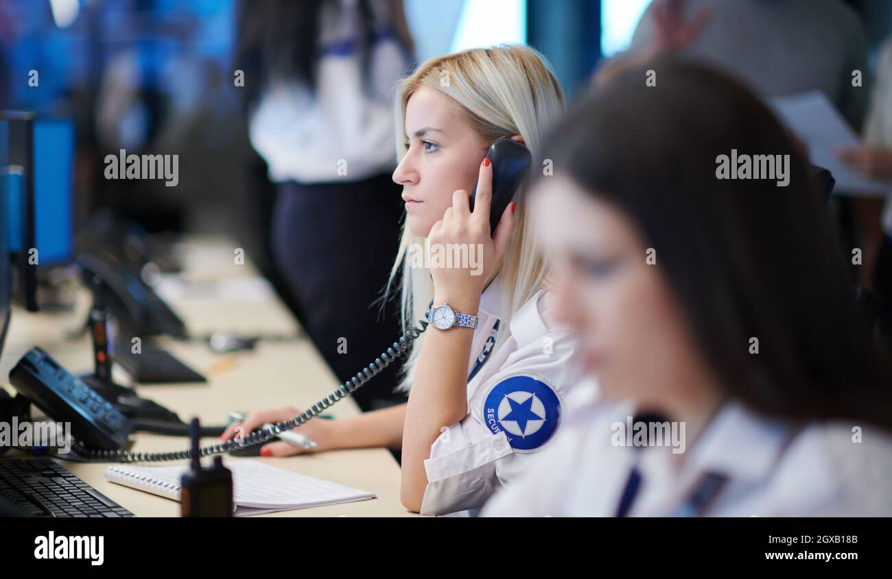 Female security guard operator talking on the phone while working at ...