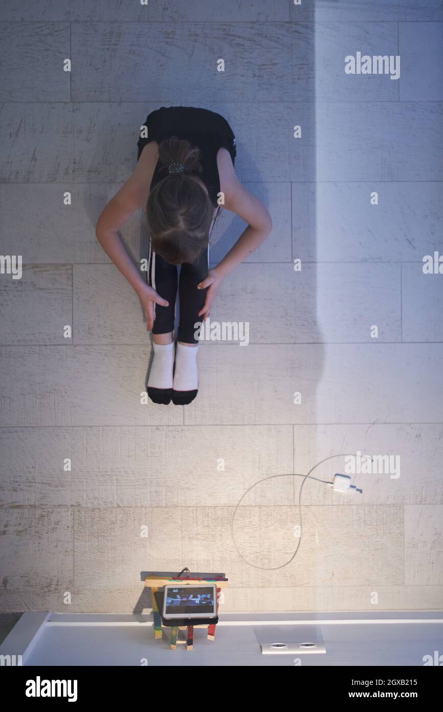 Little girl have online training while watching the tablet and doing ...