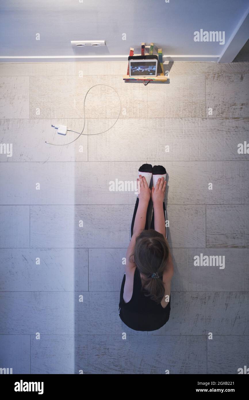 Little girl have online training while watching the tablet and doing ...