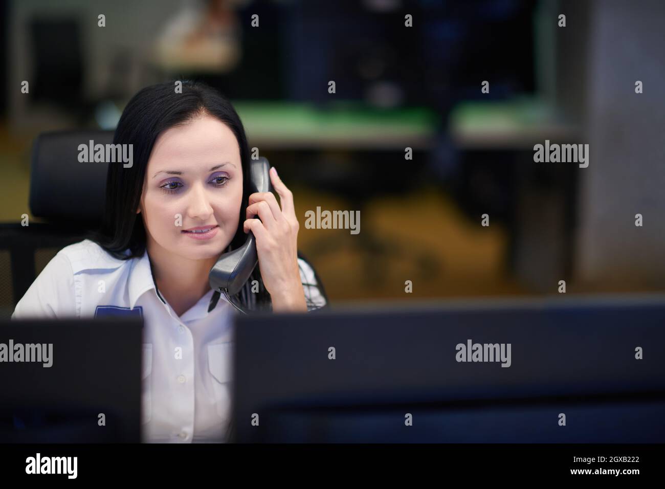 Female security guard operator talking on the phone while working at ...