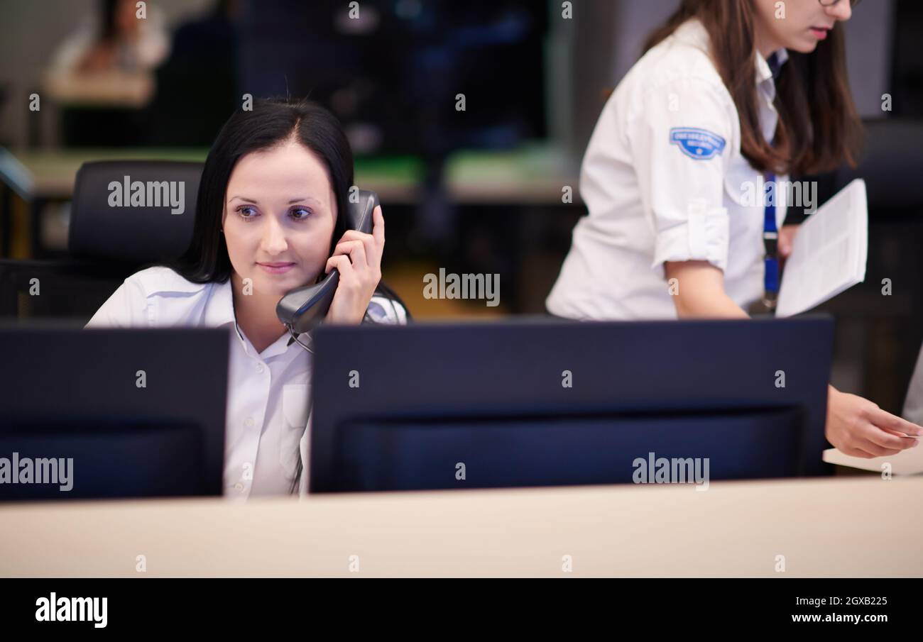 Female security guard operator talking on the phone while working at ...